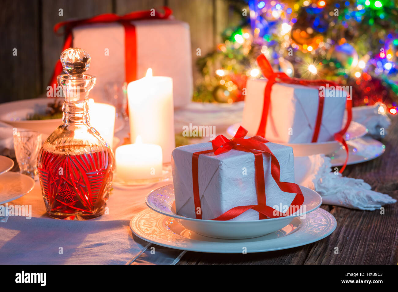 Beautiful Christmas table setting with present and tree Stock Photo - Alamy