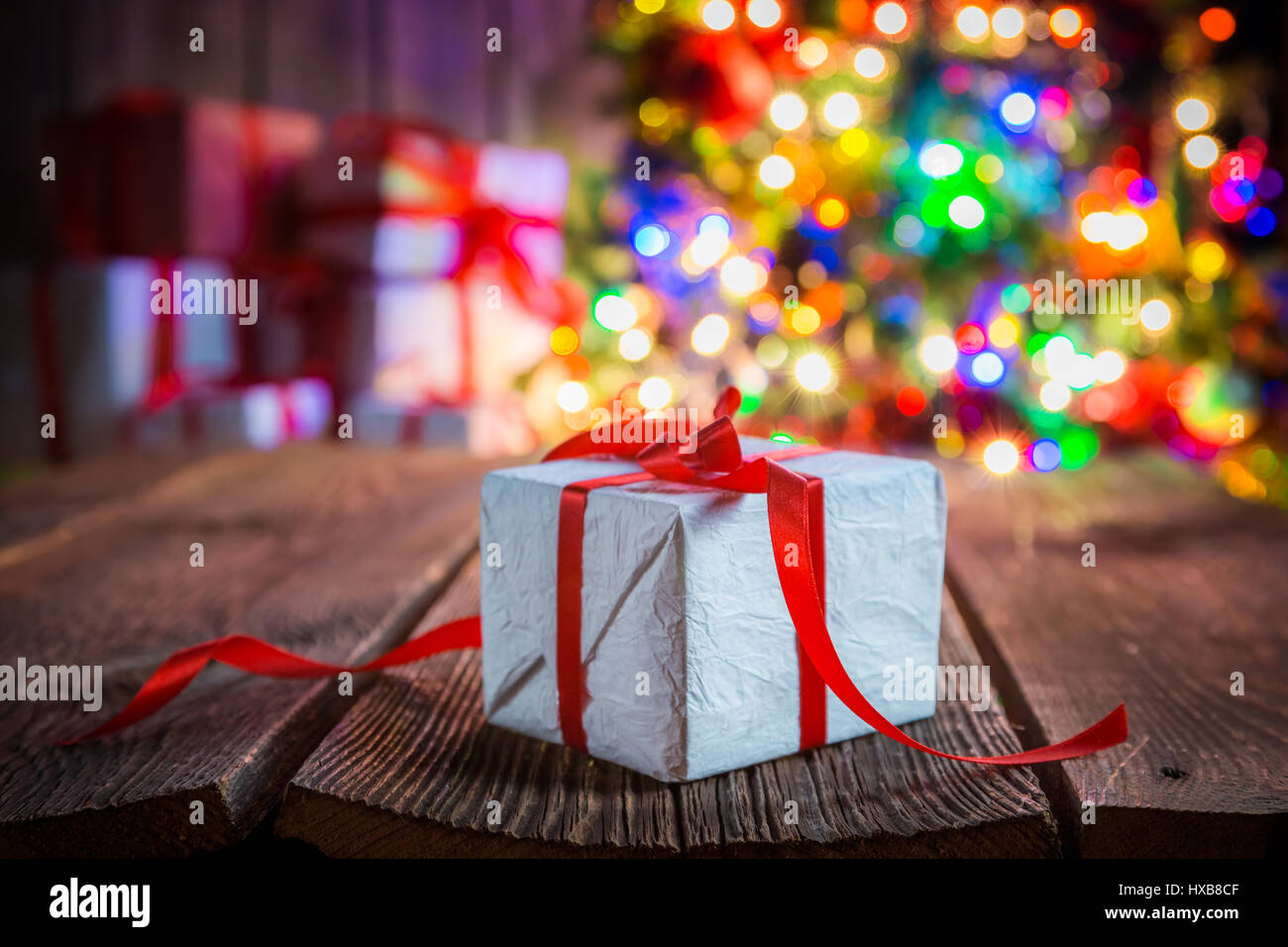 Traditionally Christmas present with tree and lights on background ...