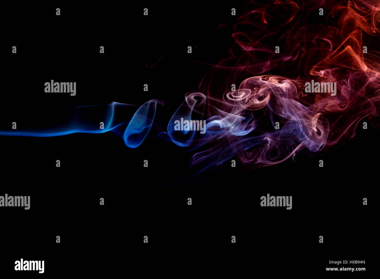 Abstract art. Color red blue smoke from the aromatic sticks on a black ...