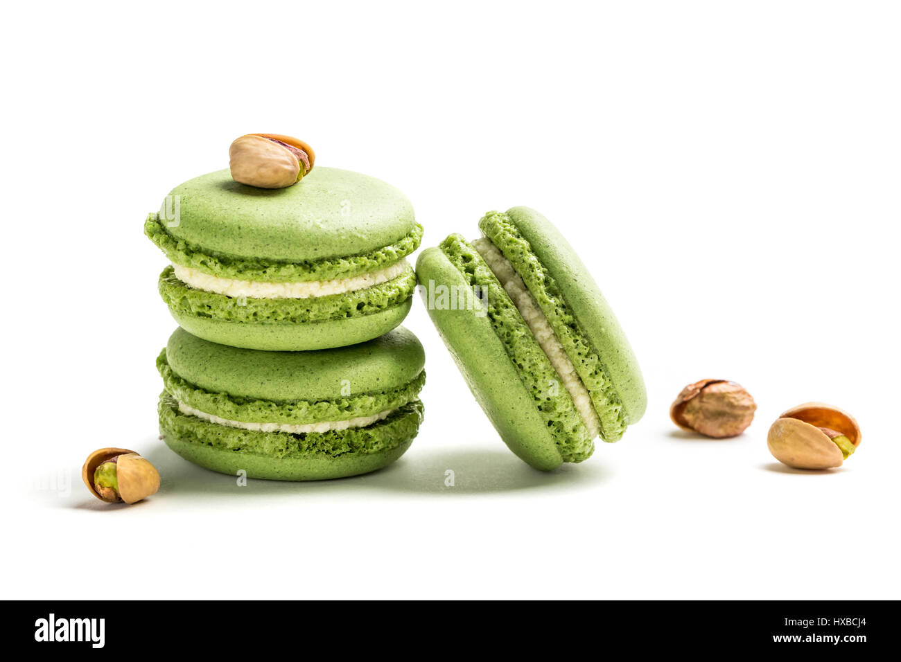 Small macaroons with pistachio on white background Stock Photo - Alamy