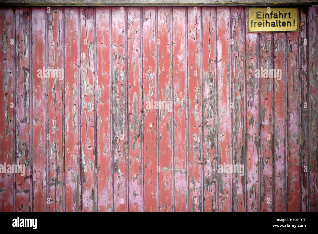 A heavily worn wooden gate with a yellow sign: keep exit Stock Photo ...