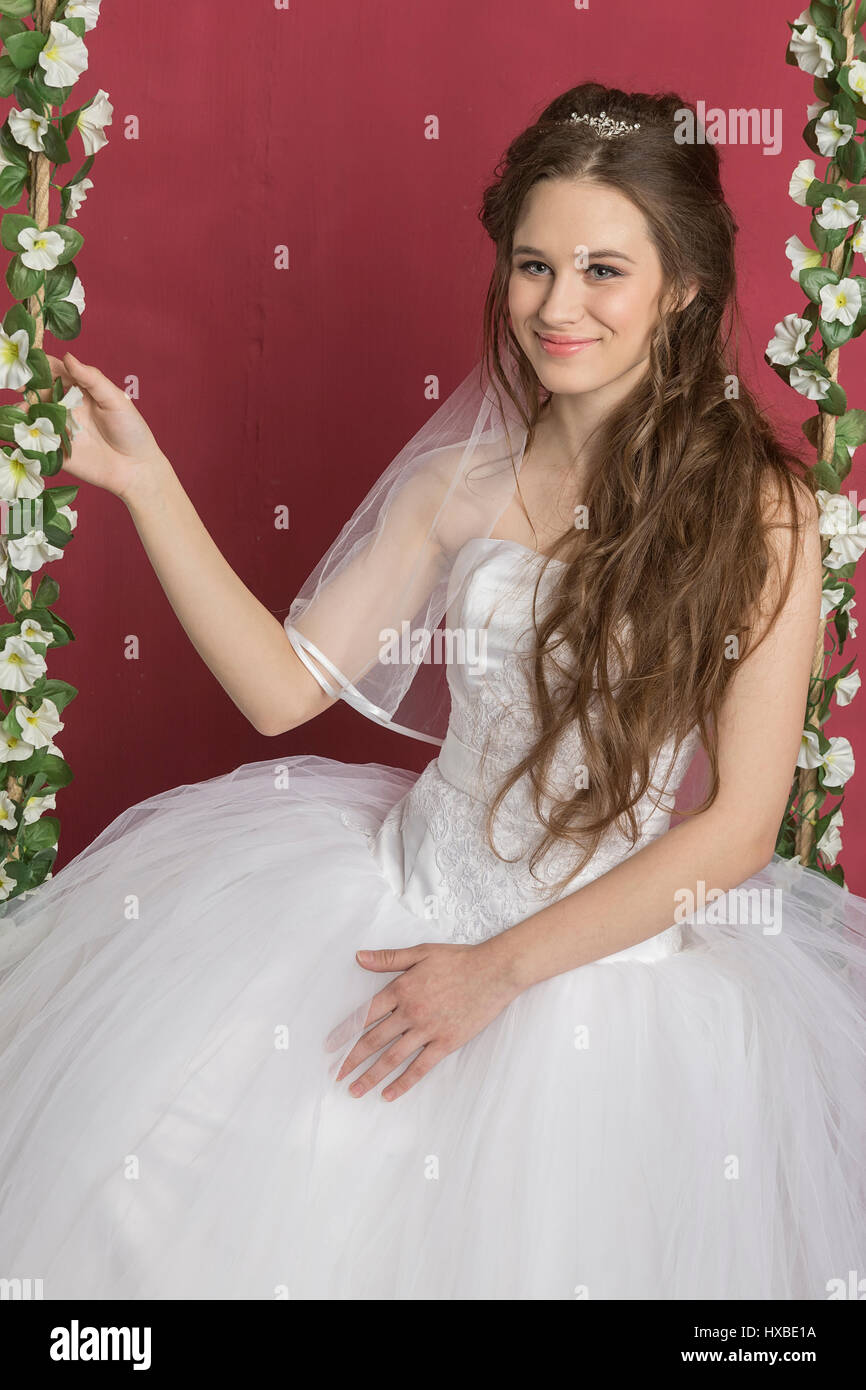 Charming bride sitting on a swing Stock Photo - Alamy