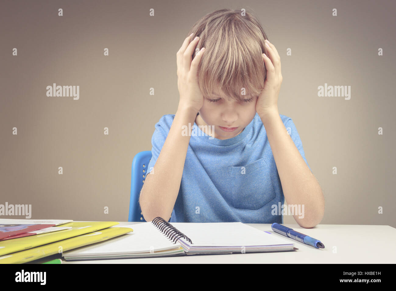 Concentrated child doing his homework at home. The boy sitting and ...