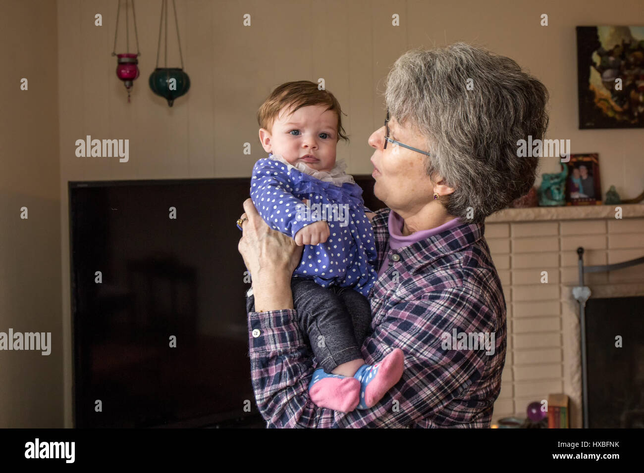 Three month old baby girl looking very concerned as her grandmother ...