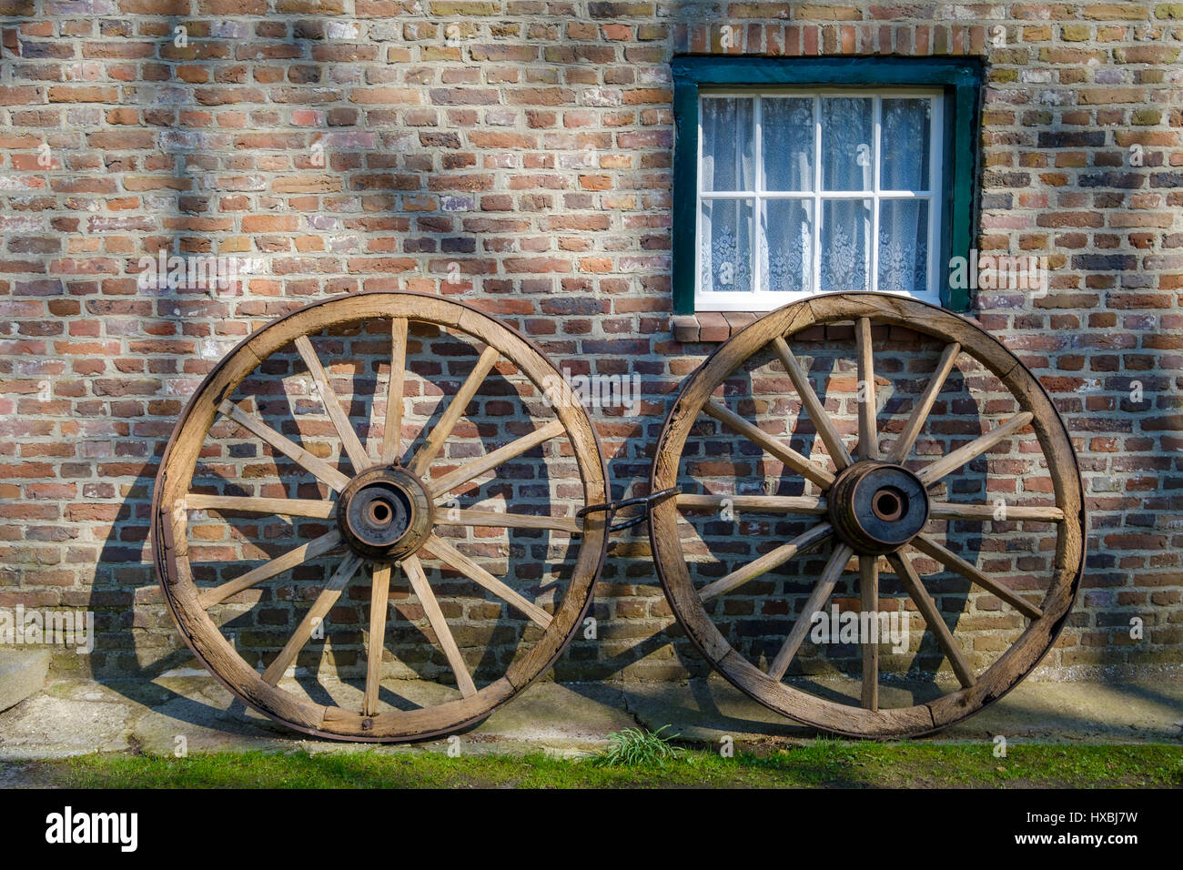 Rural wagon wheels for a brick wall, and a small window with a white ...