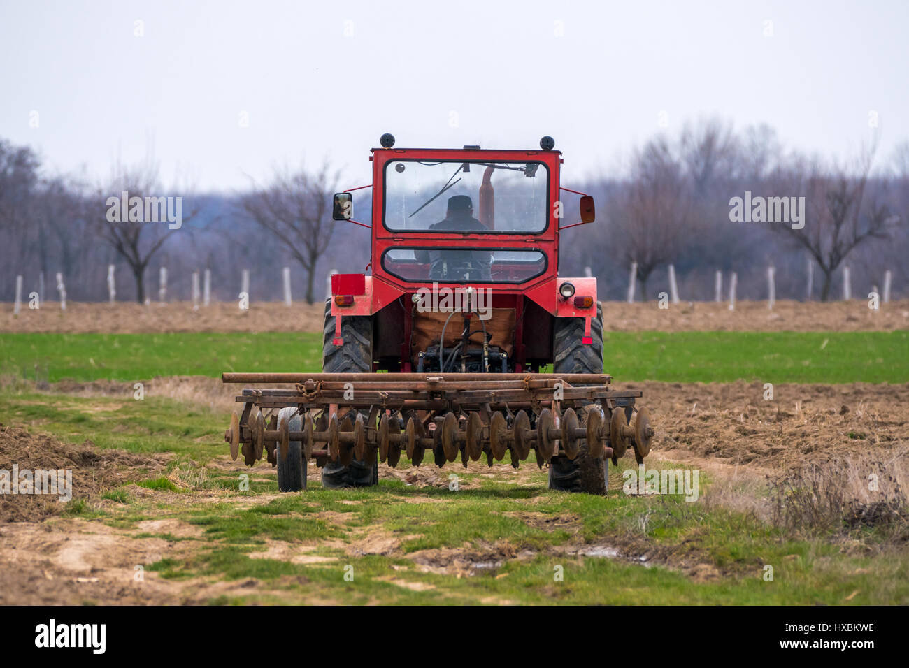 Tractor with agricultural equipment mounted on a field Stock Photo - Alamy