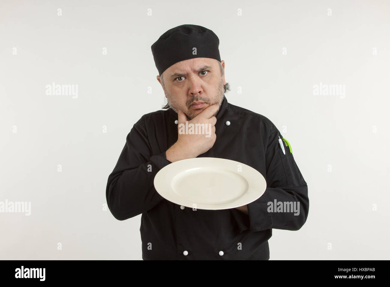 Chef Asian Senior holding a plate with confused look Stock Photo - Alamy