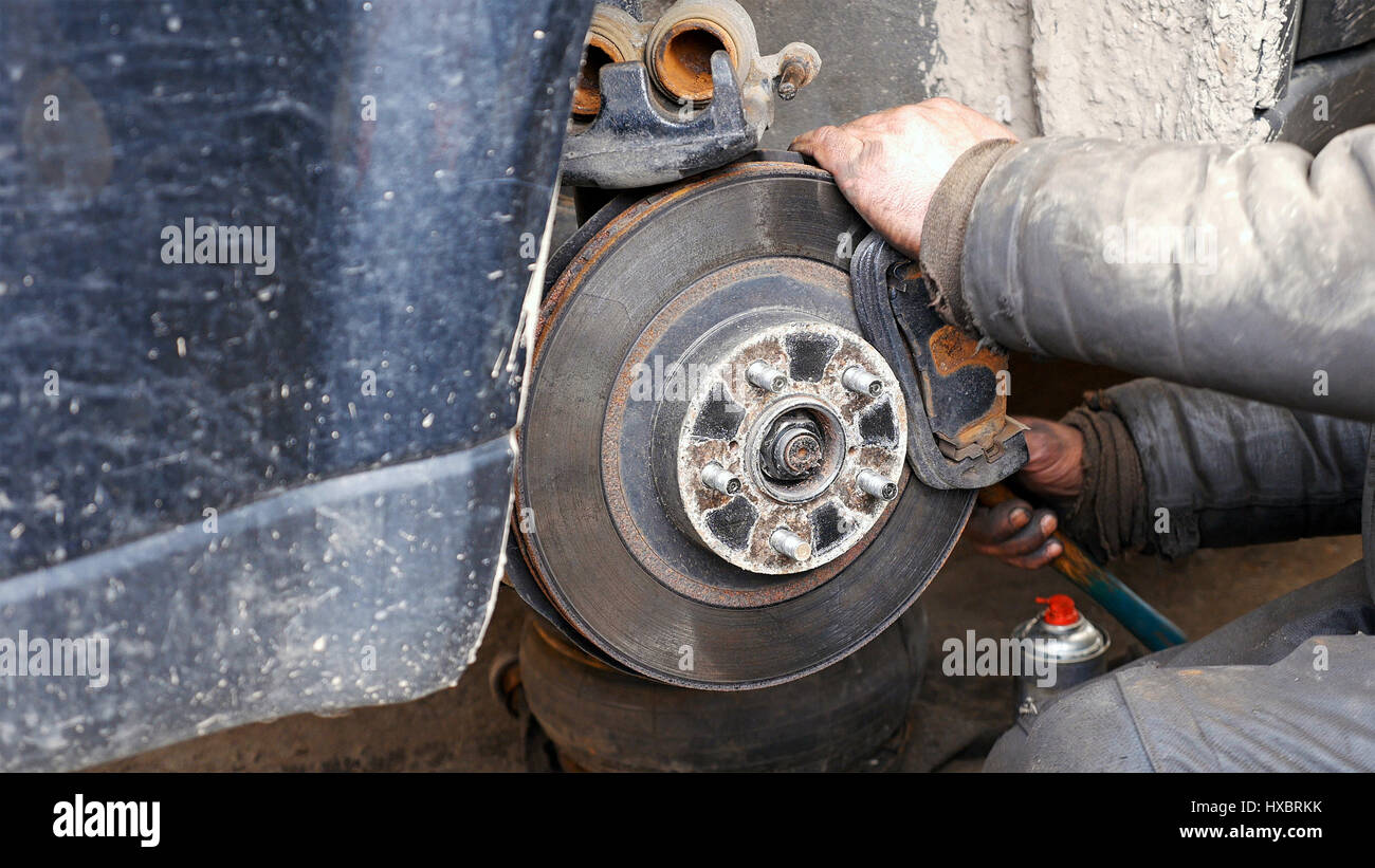 Auto mechanic working on brakes in car repair shop Stock Photo - Alamy