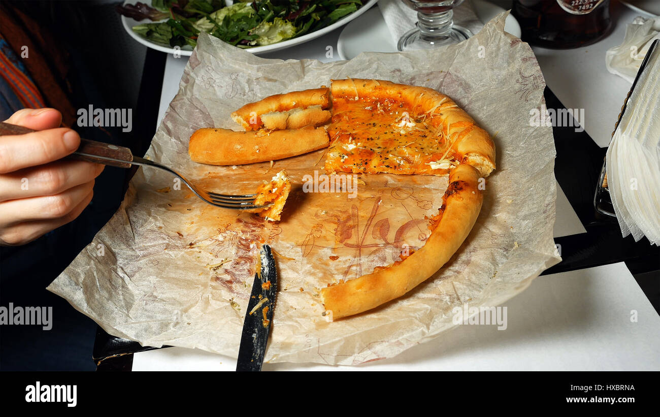 Eating pizza with fork in a cafe restaurant Stock Photo - Alamy