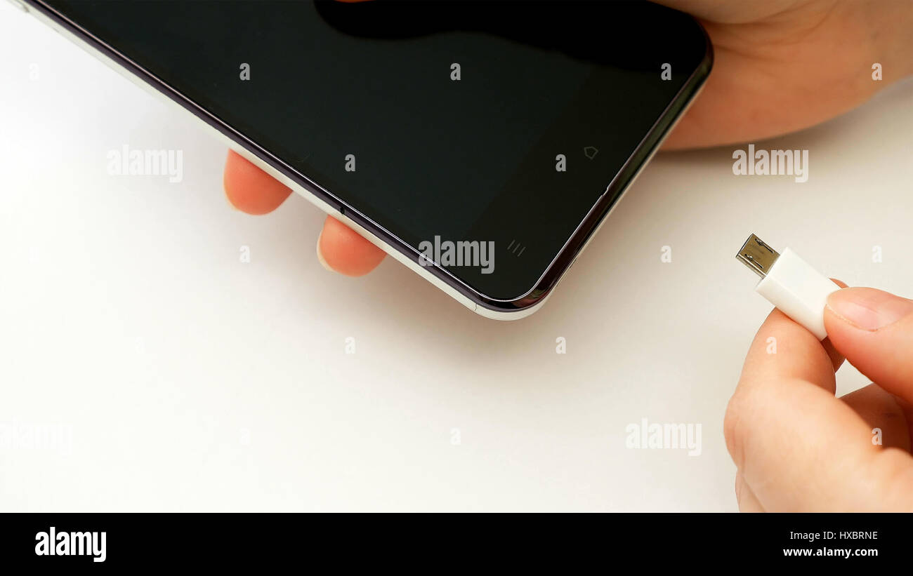 Plugging charger into mobile telephone hi-res stock photography and ...