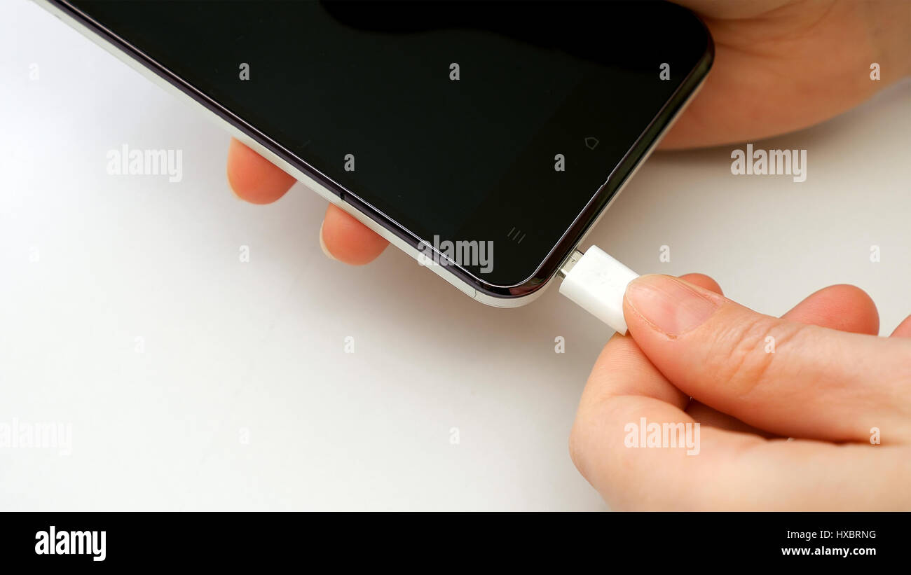 Female hand plugging charger cell phone smartphone Stock Photo - Alamy