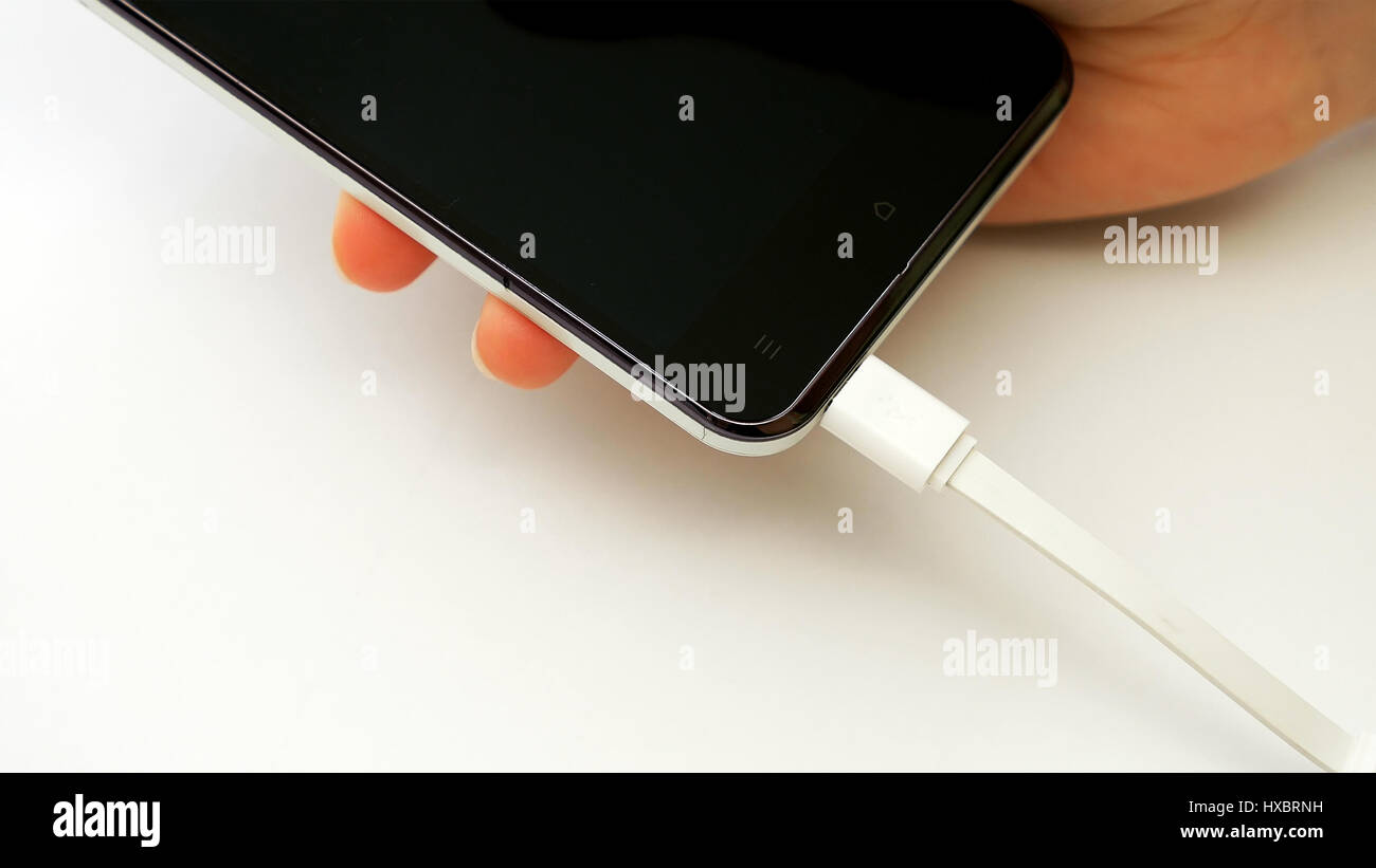 Plugging charger into mobile telephone hi-res stock photography and ...