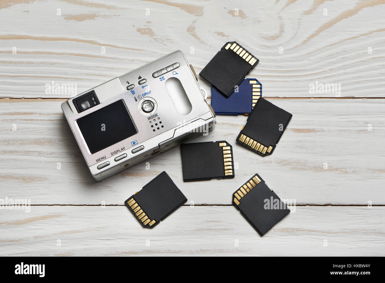 Flash cards SD and compact digital camera close-up on wooden background ...