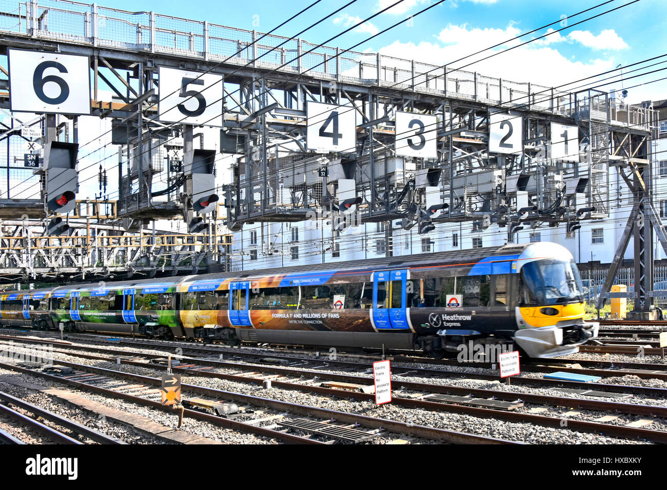 Heathrow Express train colourful advertising on carriages passing ...