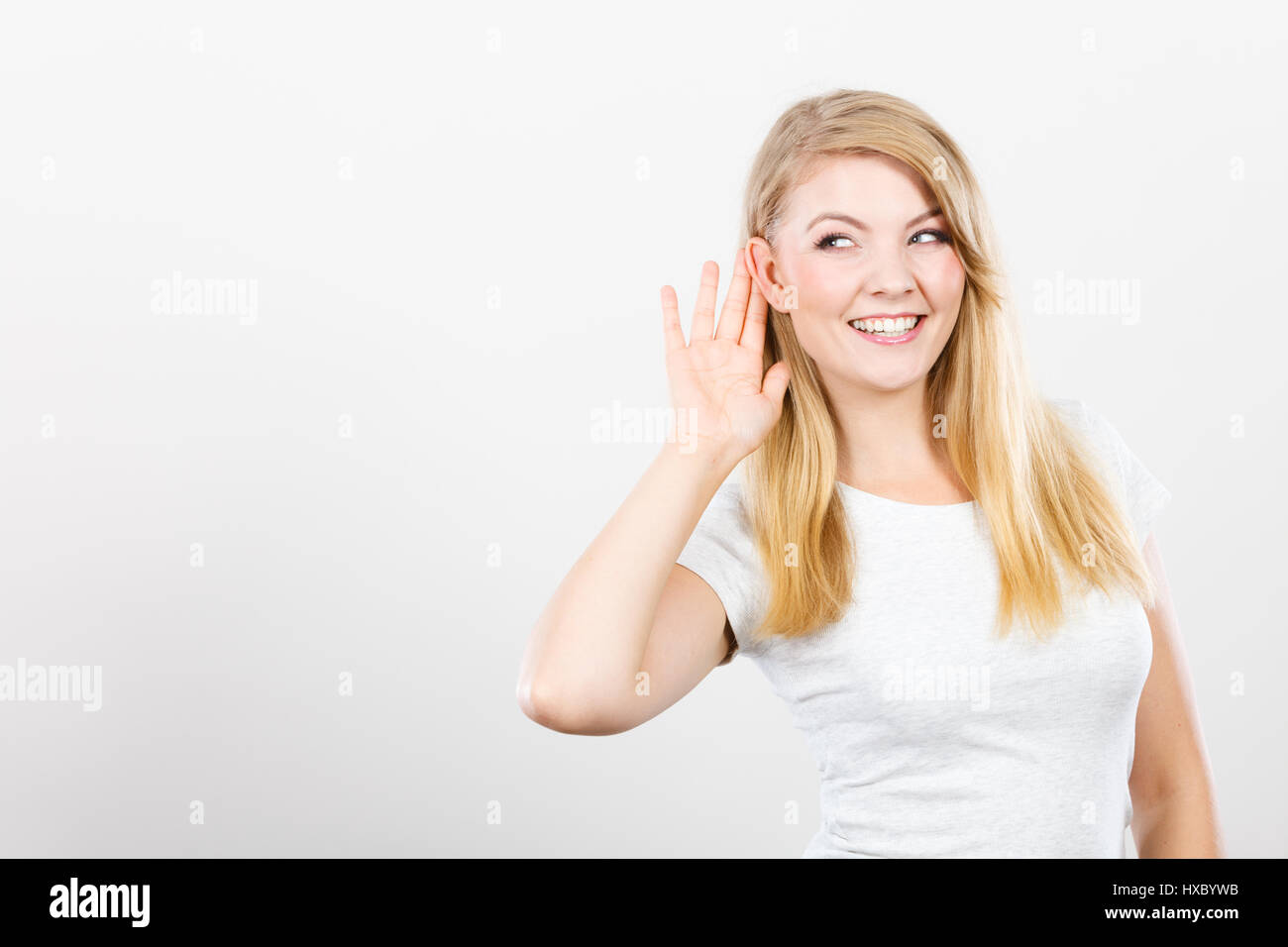 Gossip,rumors, whisper, hearing concept. Young blonde Woman putting ...