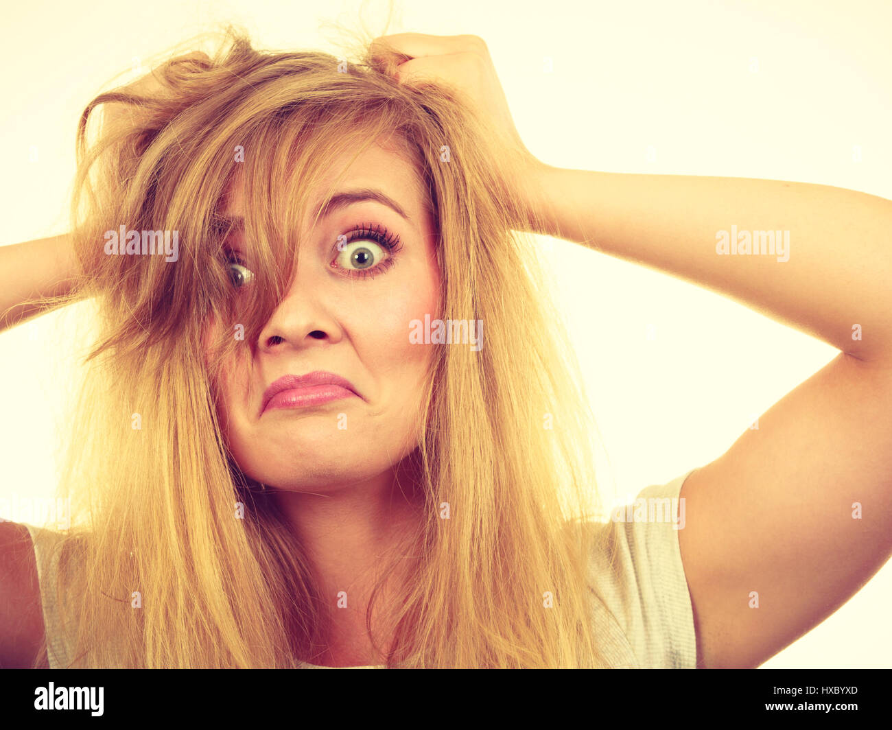 Bad hairstyle concept. Crazy, mad blonde woman with messy hair looking ...