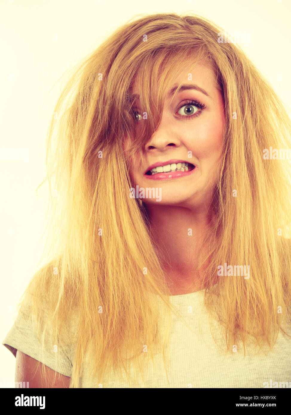 Bad hairstyle concept. Crazy, mad blonde woman with messy hair looking ...