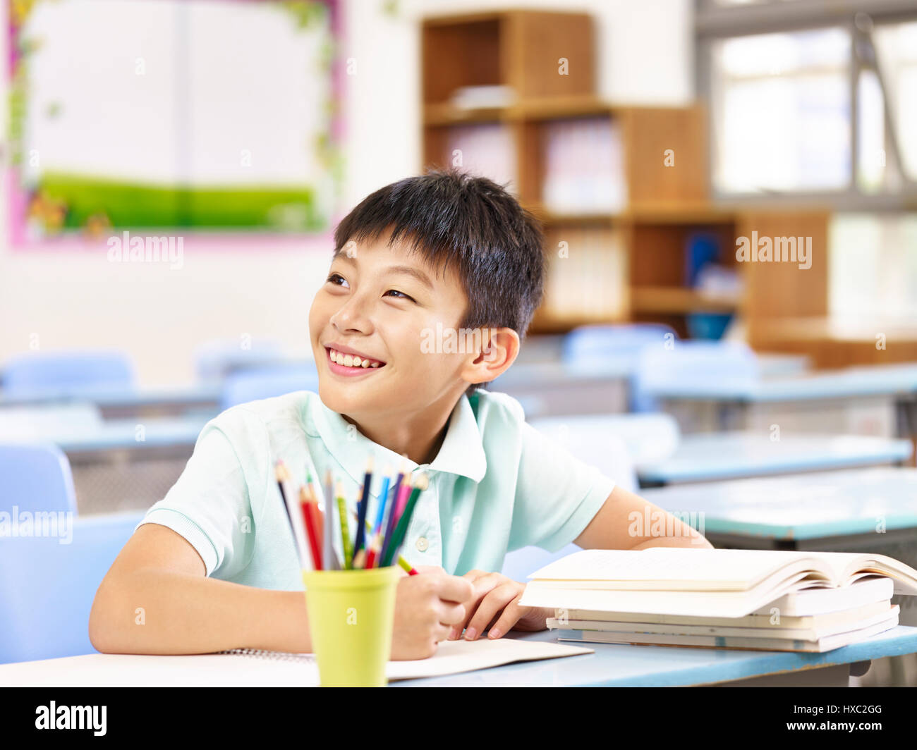asian elementary school student looking away smiling while studying in classroom Stock Photo - Alamy