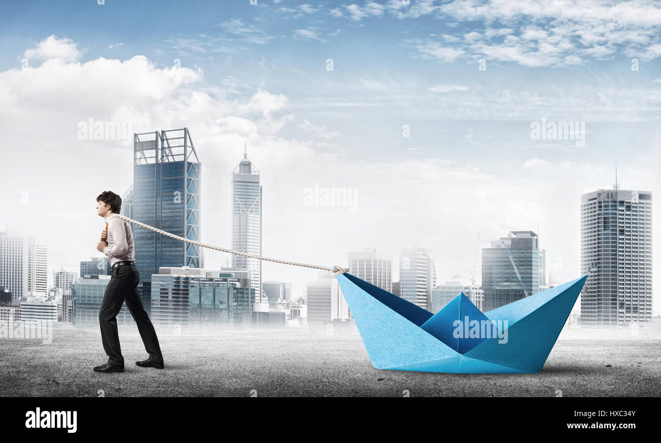 Successful businessman pulling with rope paper boat Stock Photo - Alamy