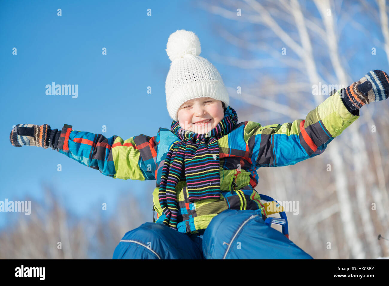 Little cute boy riding sled in winter park Stock Photo - Alamy