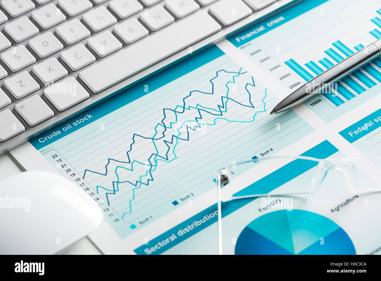 Business workplace with keyboard mouse and papers with graphs and ...