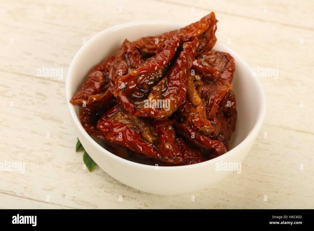 Dried tomato in olive oil with basil leaves Stock Photo - Alamy