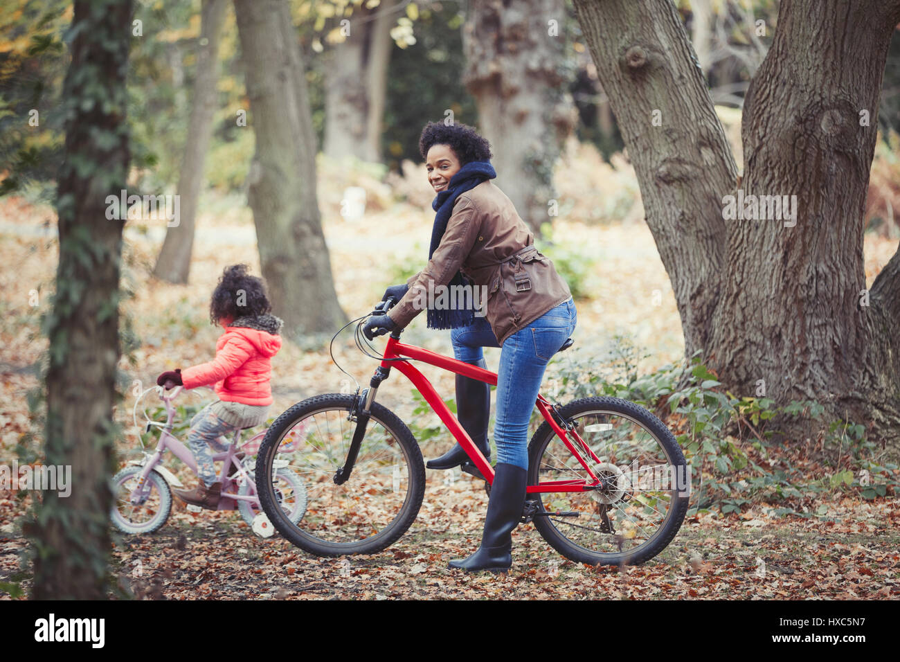 Mother and daughter bike riding in autumn woods Stock Photo - Alamy