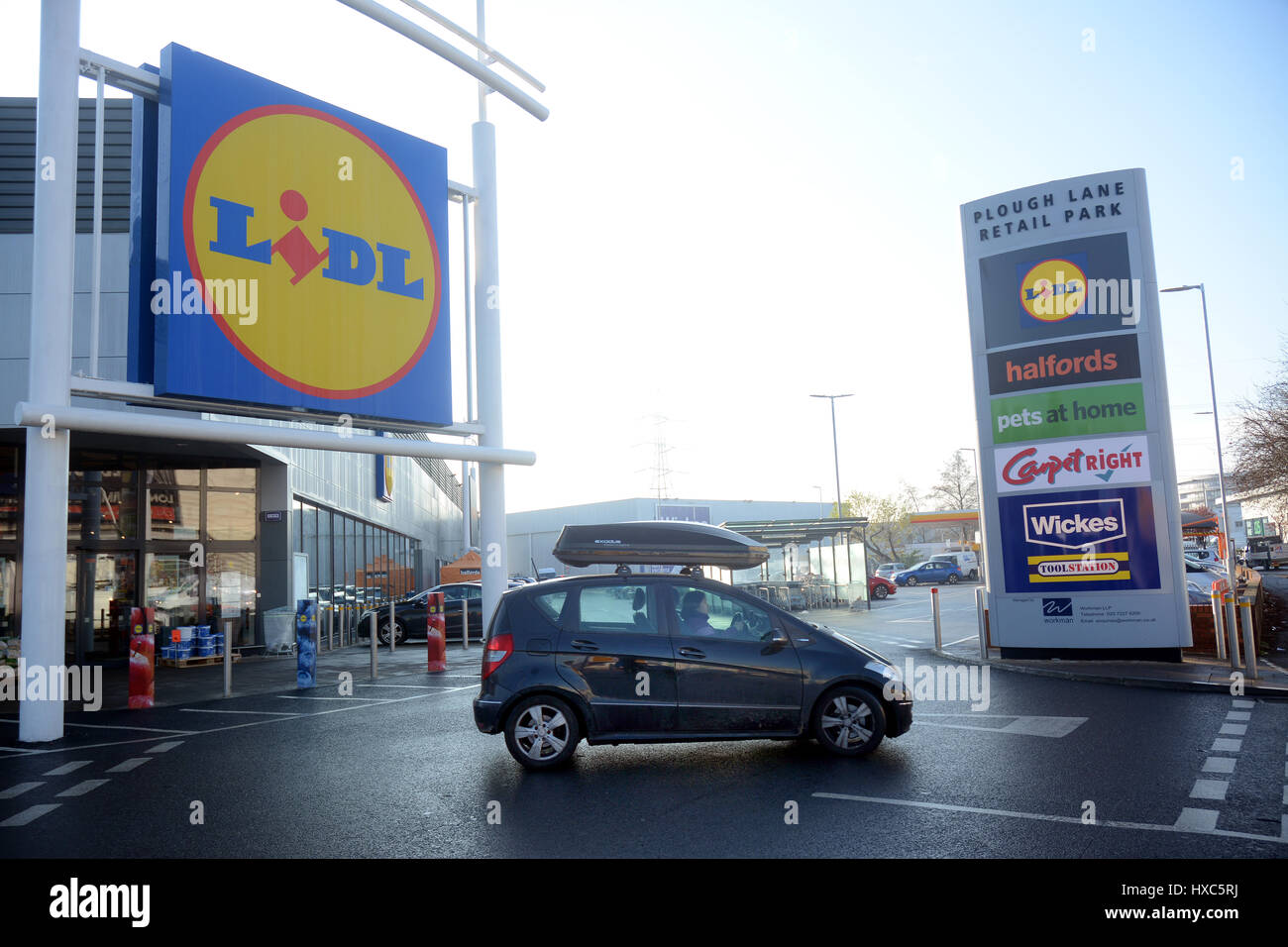 A shopper in a car leaves the car park at the Plough Lane Retail Park ...