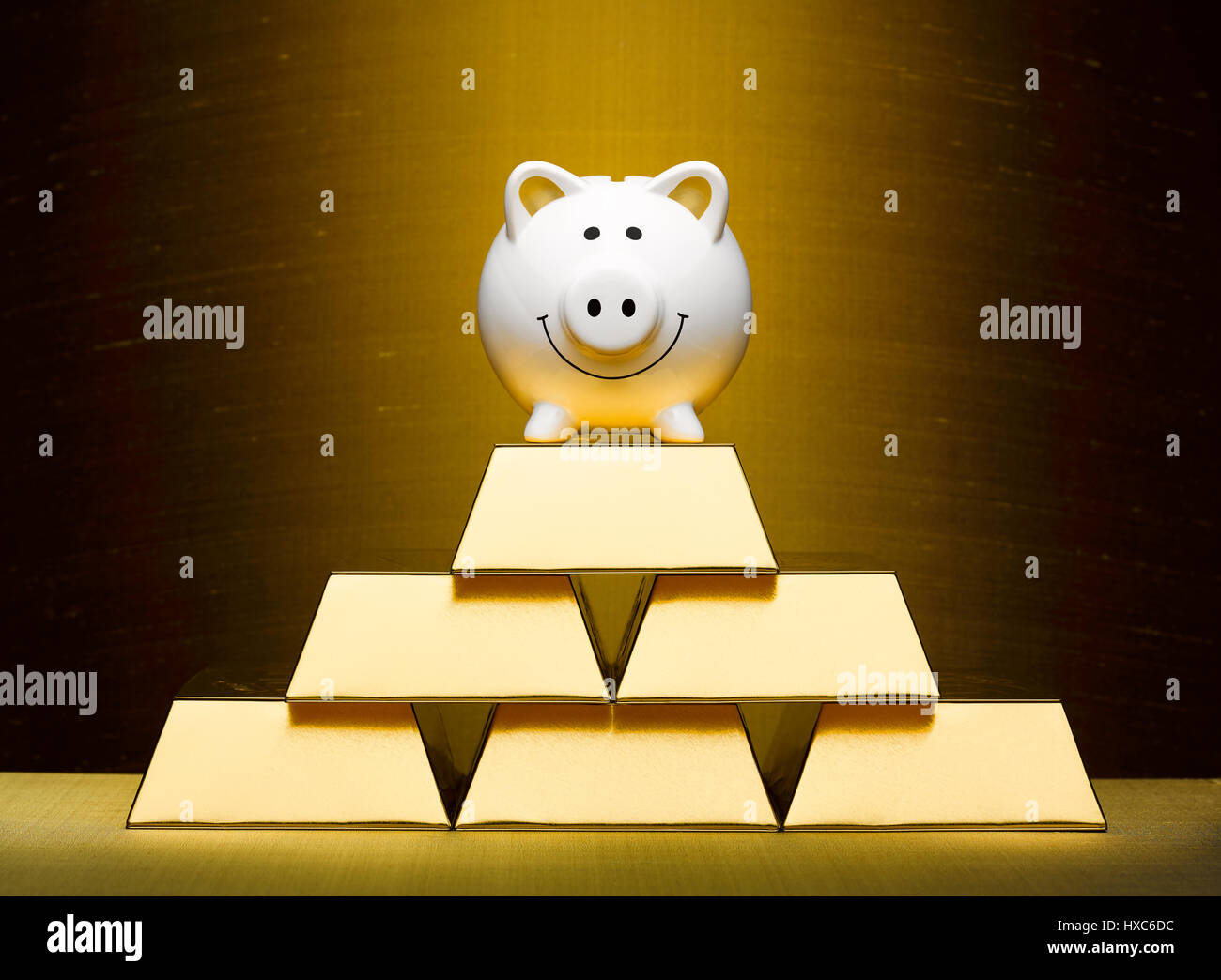 Smiling piggy bank on top of stacked gold bars Stock Photo - Alamy