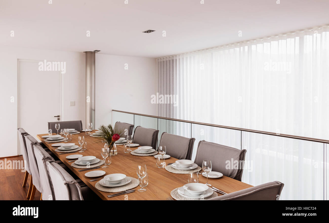 Modern, luxury home showcase interior dining room with placesettings on ...