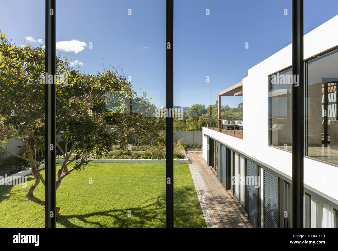 View from windows of sunny modern luxury home showcase exterior with ...