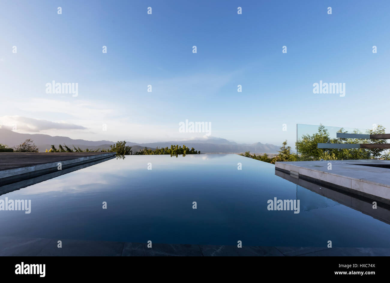 Tranquil luxury infinity pool with mountain view below blue sky Stock ...