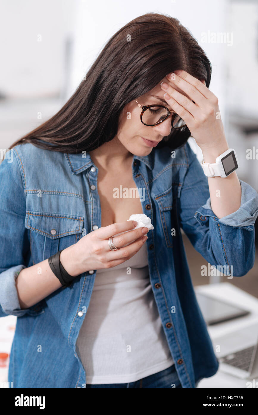 Attentive female person touching her forehead Stock Photo - Alamy