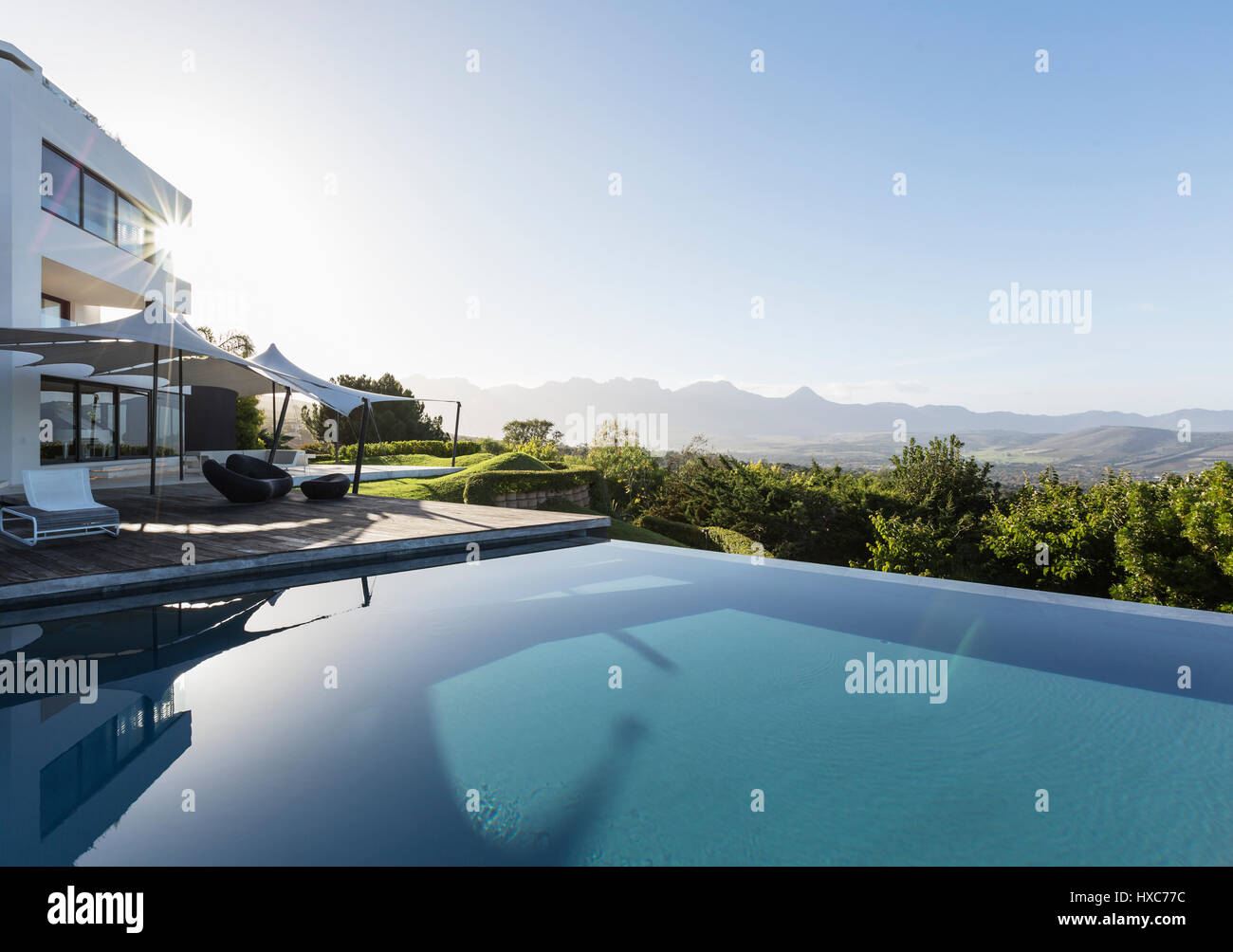 Tranquil, sunny home showcase exterior with infinity pool and mountain ...