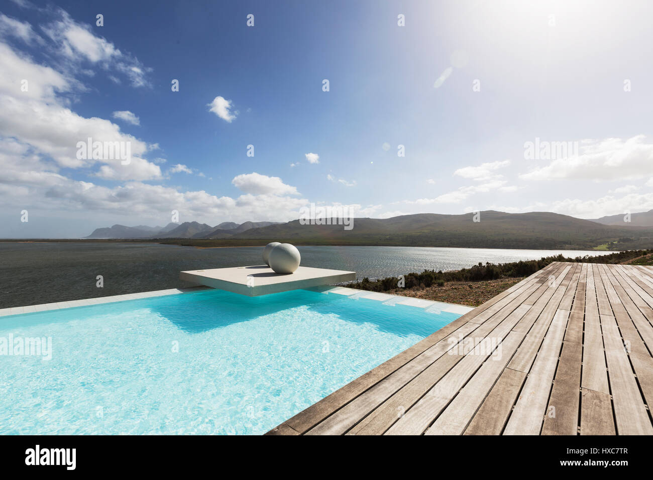 Sunny tranquil modern infinity pool with ocean view Stock Photo - Alamy