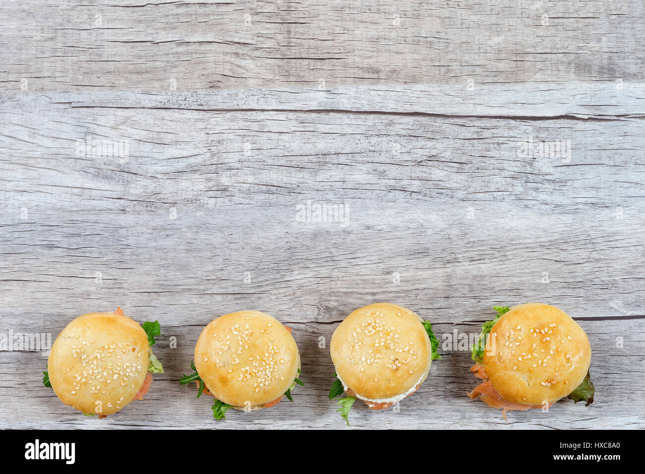 puff burger with smoked salmon in line top view on old wooden board ...