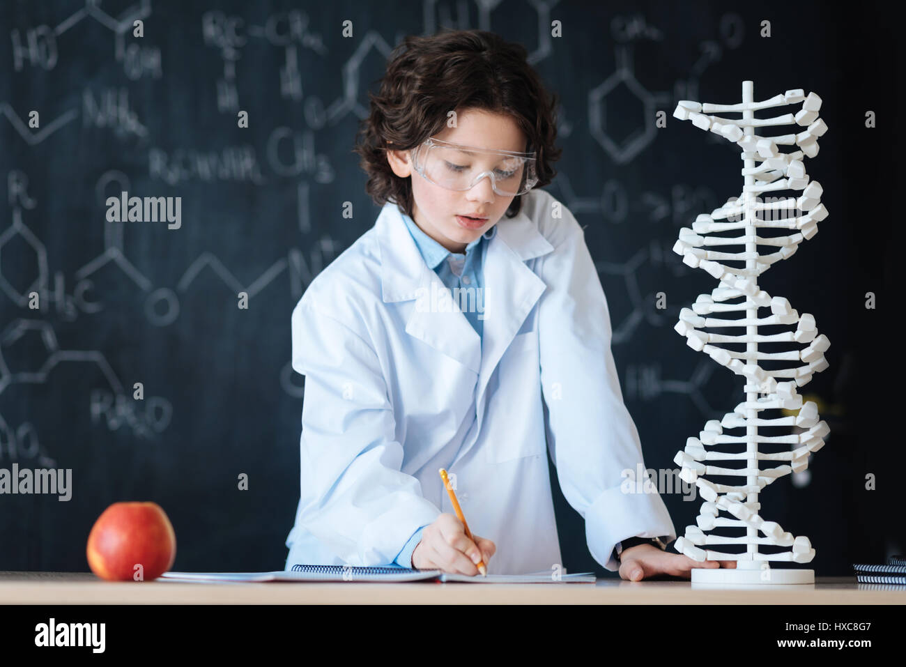 Gifted kid taking notes in the laboratory Stock Photo - Alamy