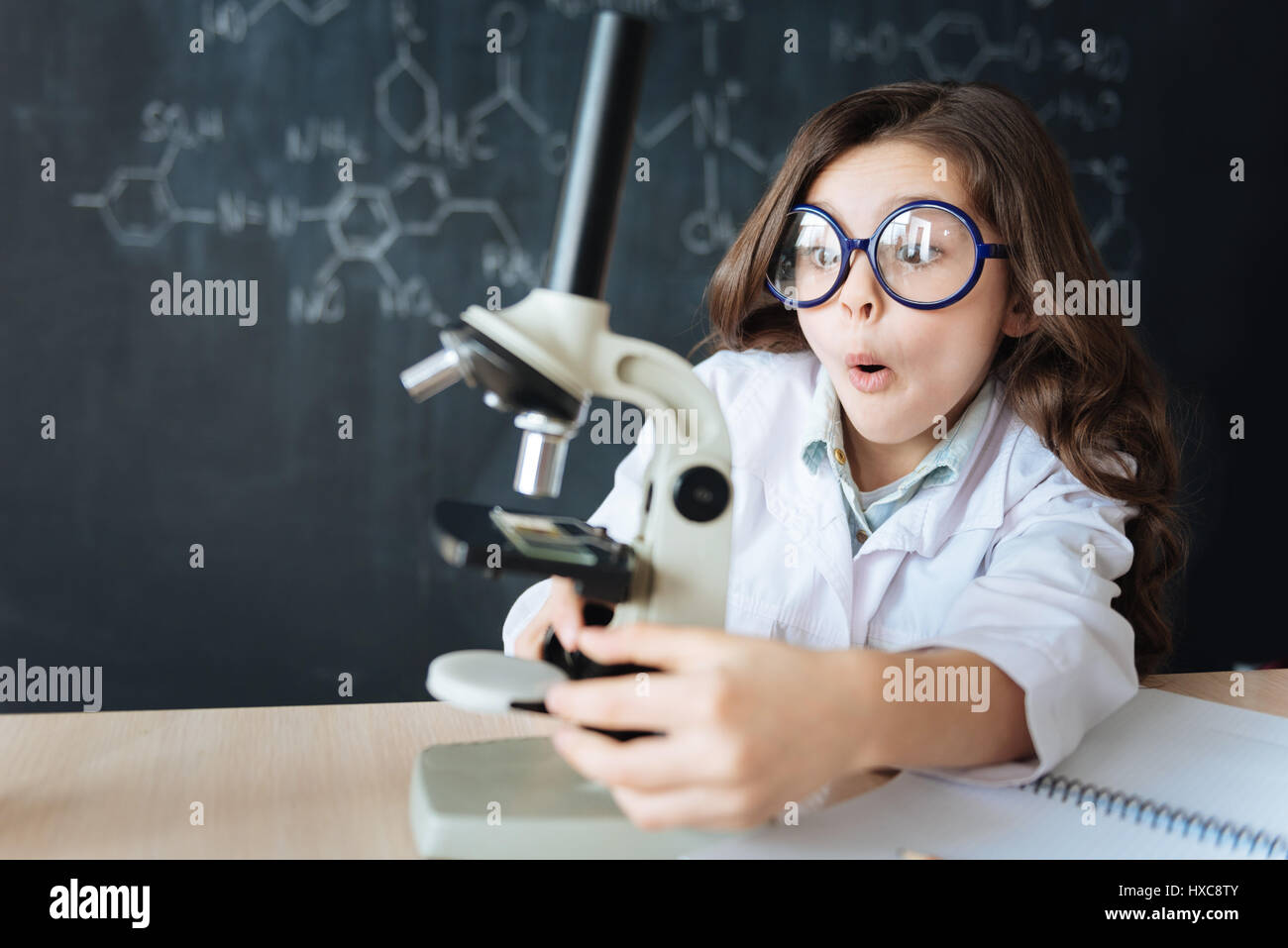 Shocked little scientist using science equipment in the laboratory ...