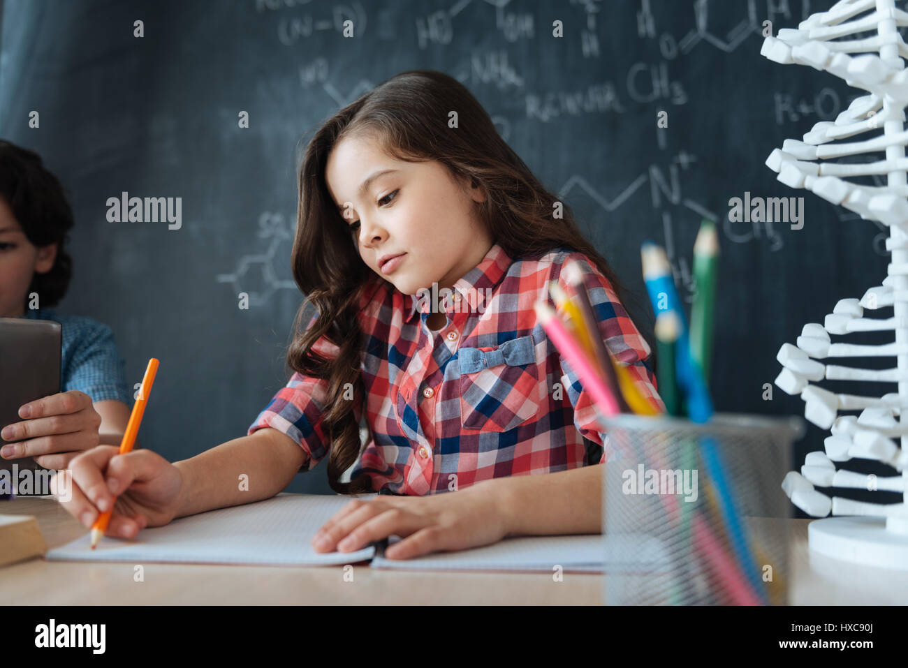 Involved little girl doing science homework at school Stock Photo - Alamy