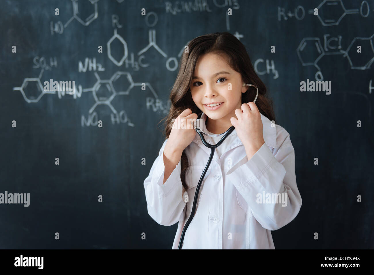 Cute young girl testing stethoscope at school Stock Photo - Alamy