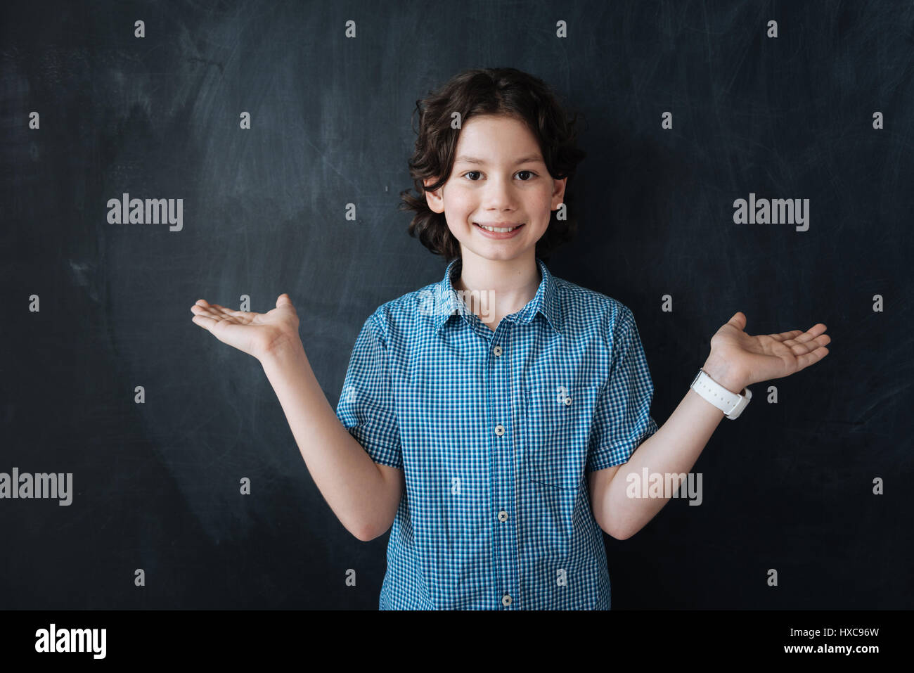 Smiling boy offering a choice in the black colored studio Stock Photo ...