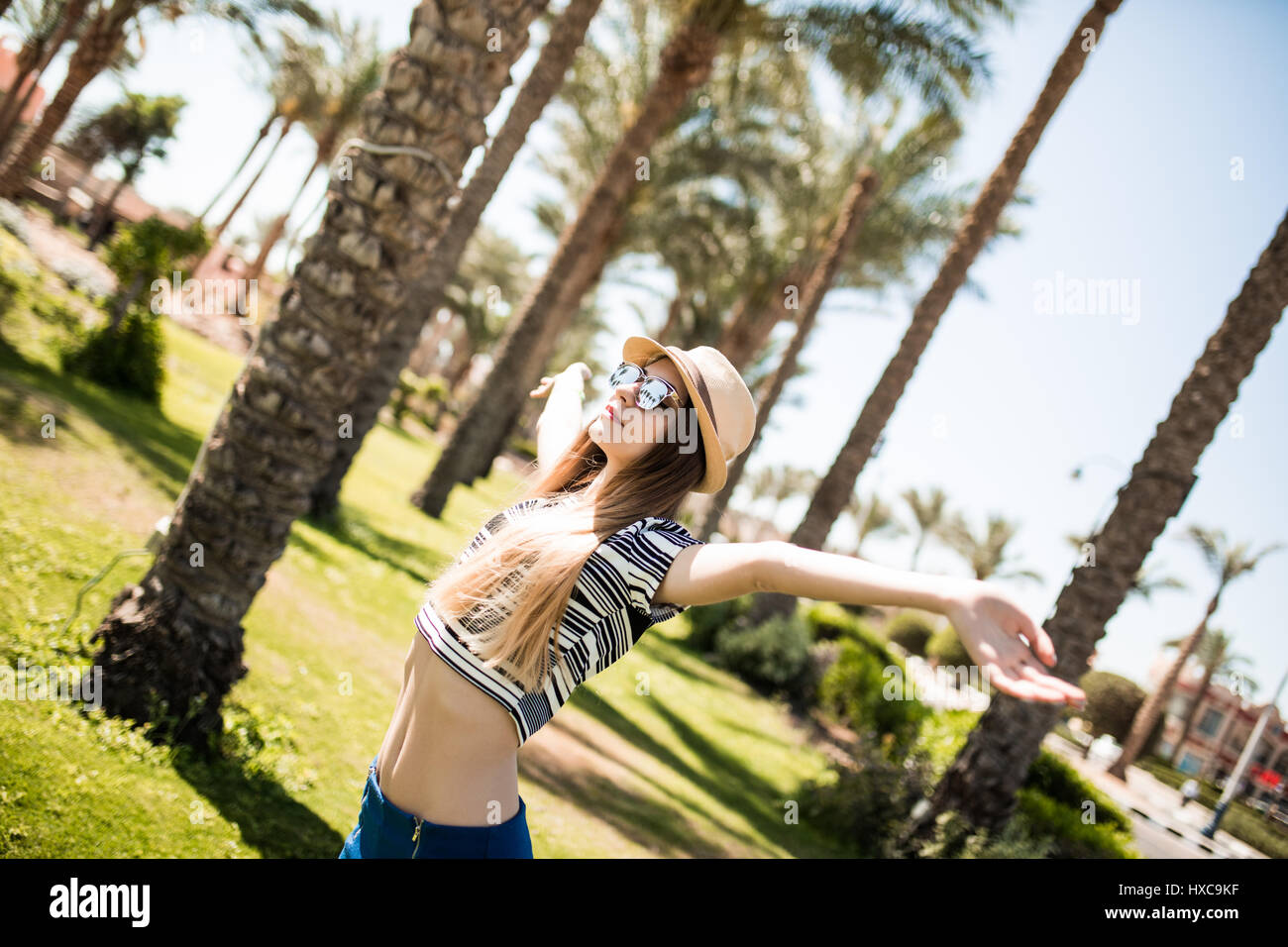 view of happy excited young woman with raised hands walking and ...