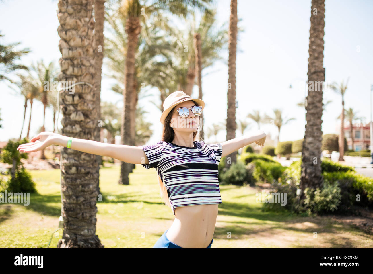 view of happy excited young woman with raised hands walking and ...