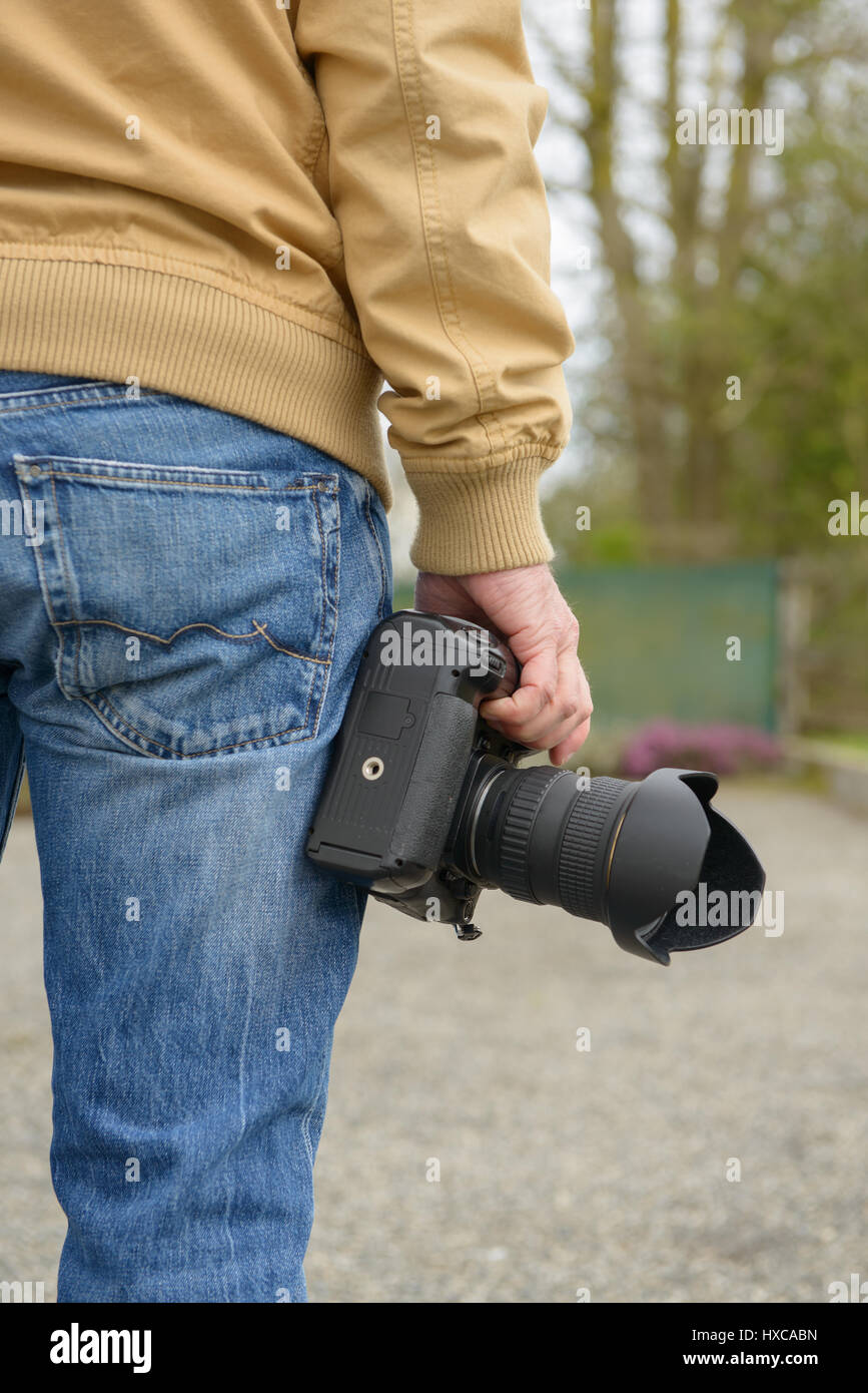 man photographer holding his photo camera, outdoor Stock Photo - Alamy