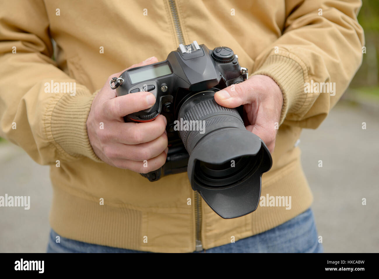 man photographer holding his photo camera, outdoor Stock Photo - Alamy
