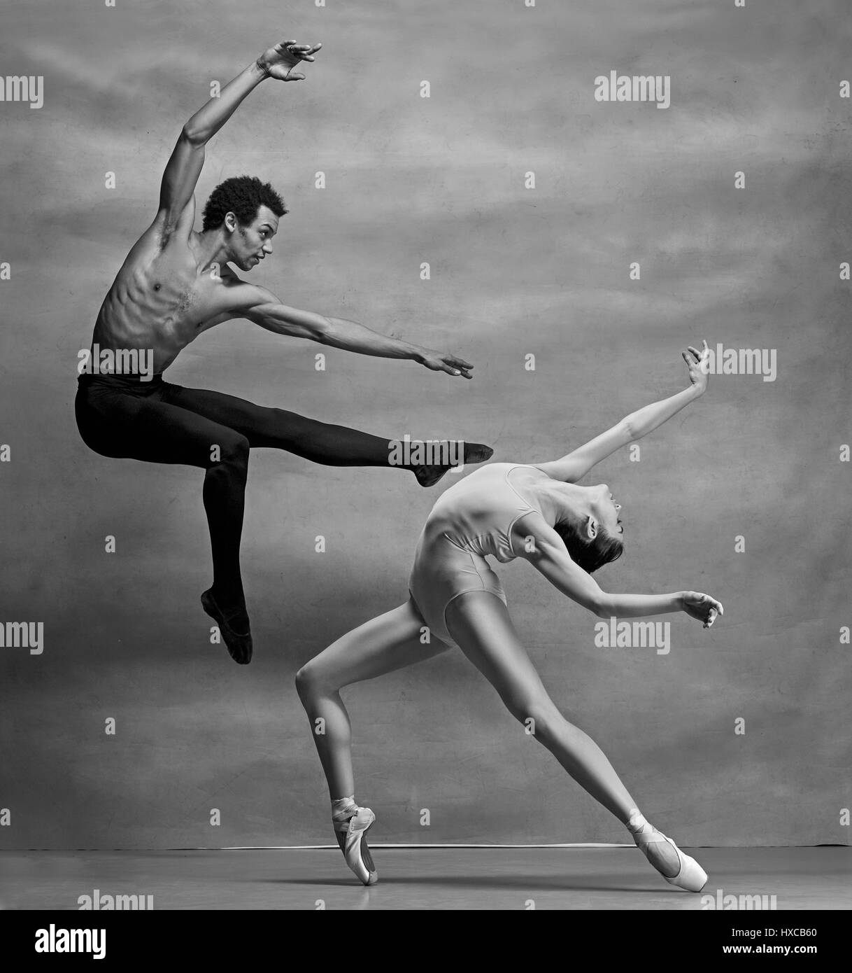 Couple of ballet dancers posing over gray background Stock Photo - Alamy