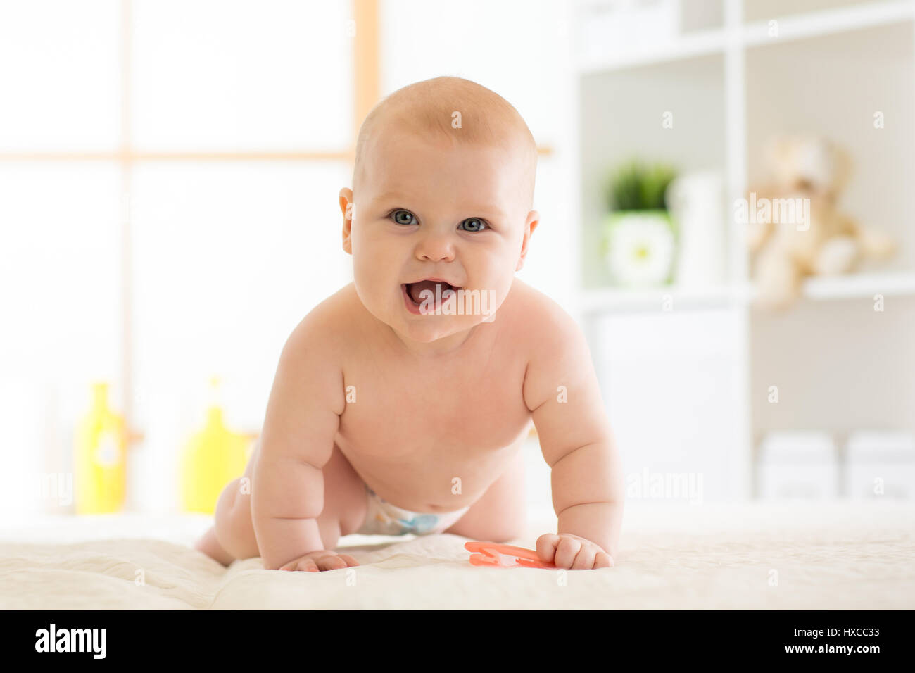 Joyful baby crawling on the floor in nursery room Stock Photo - Alamy