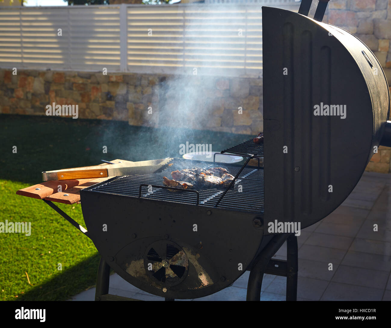 Barbecue with smoke side view in a masonry turf backyard Stock Photo ...