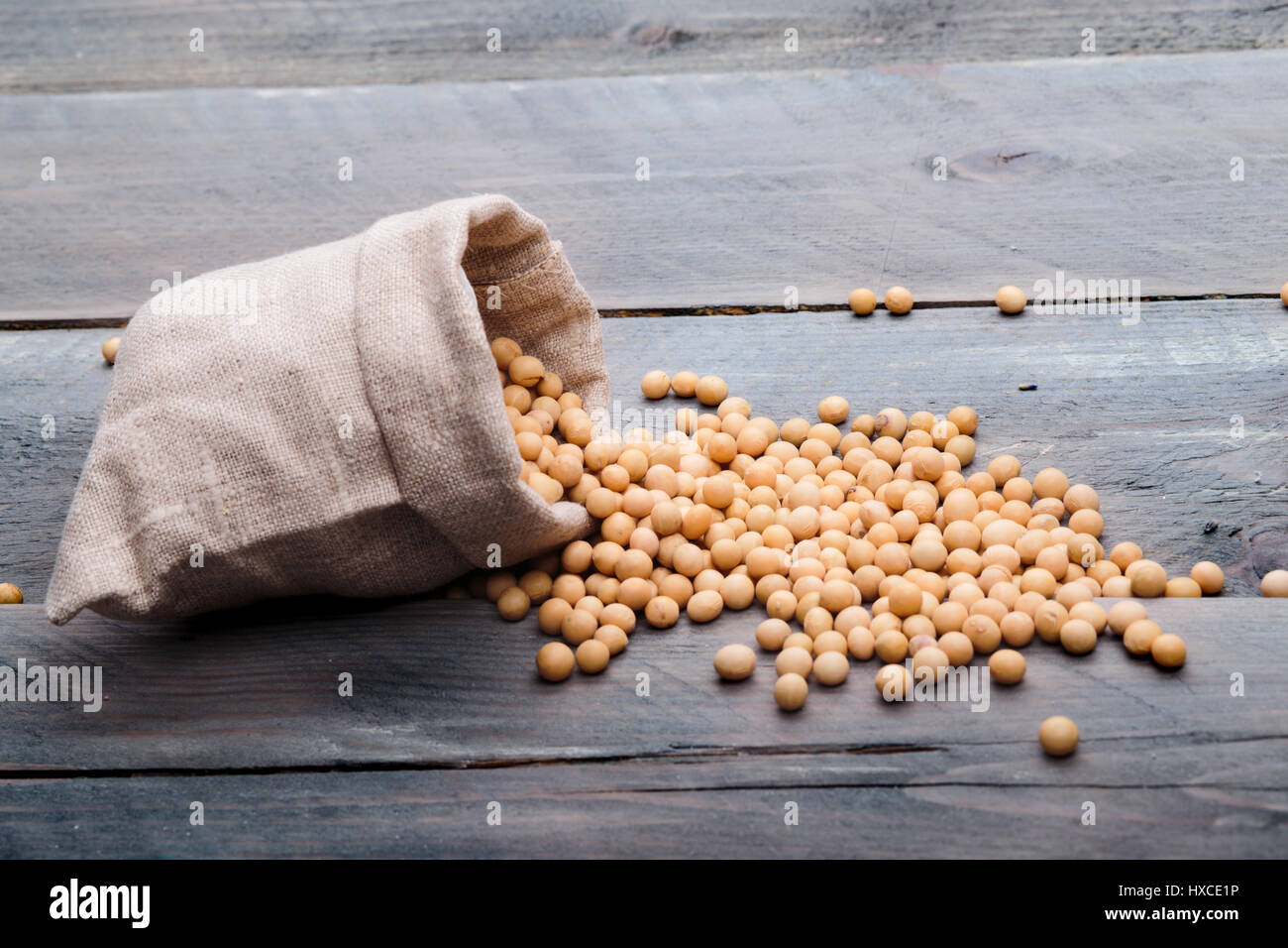 Soya beans in a sack on wooden table Stock Photo - Alamy