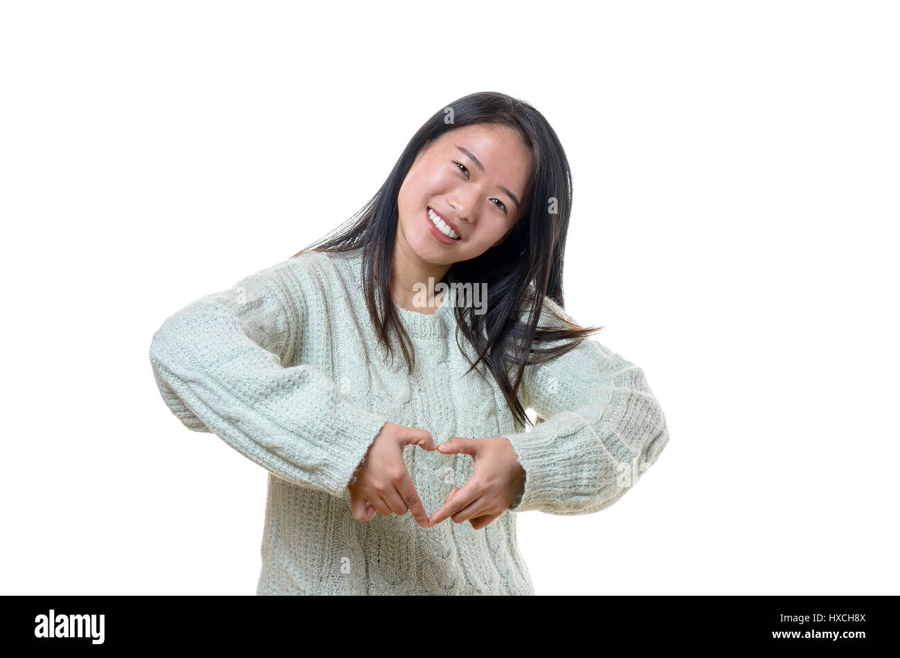 Romantic young Chinese woman making a heart sign gesture with her ...